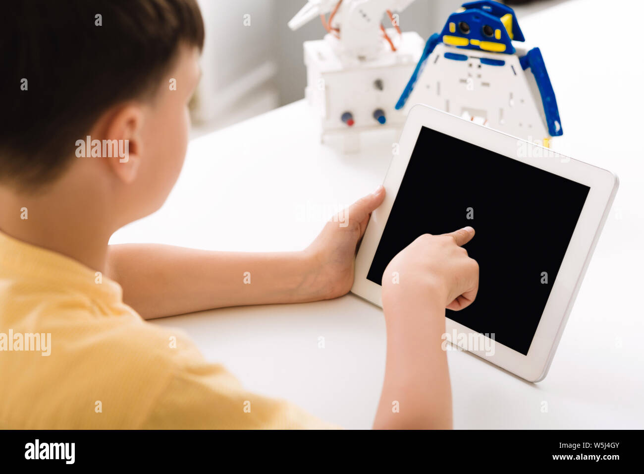Boy programming electric toy with tablet computer Stock Photo - Alamy