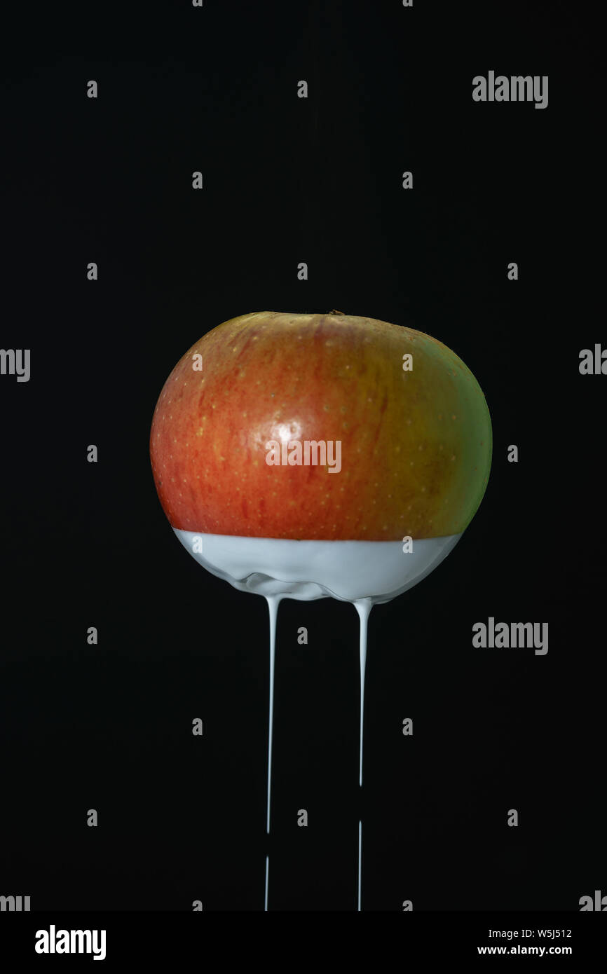 Dripping white paint of apple on a black background. Creative poster ...
