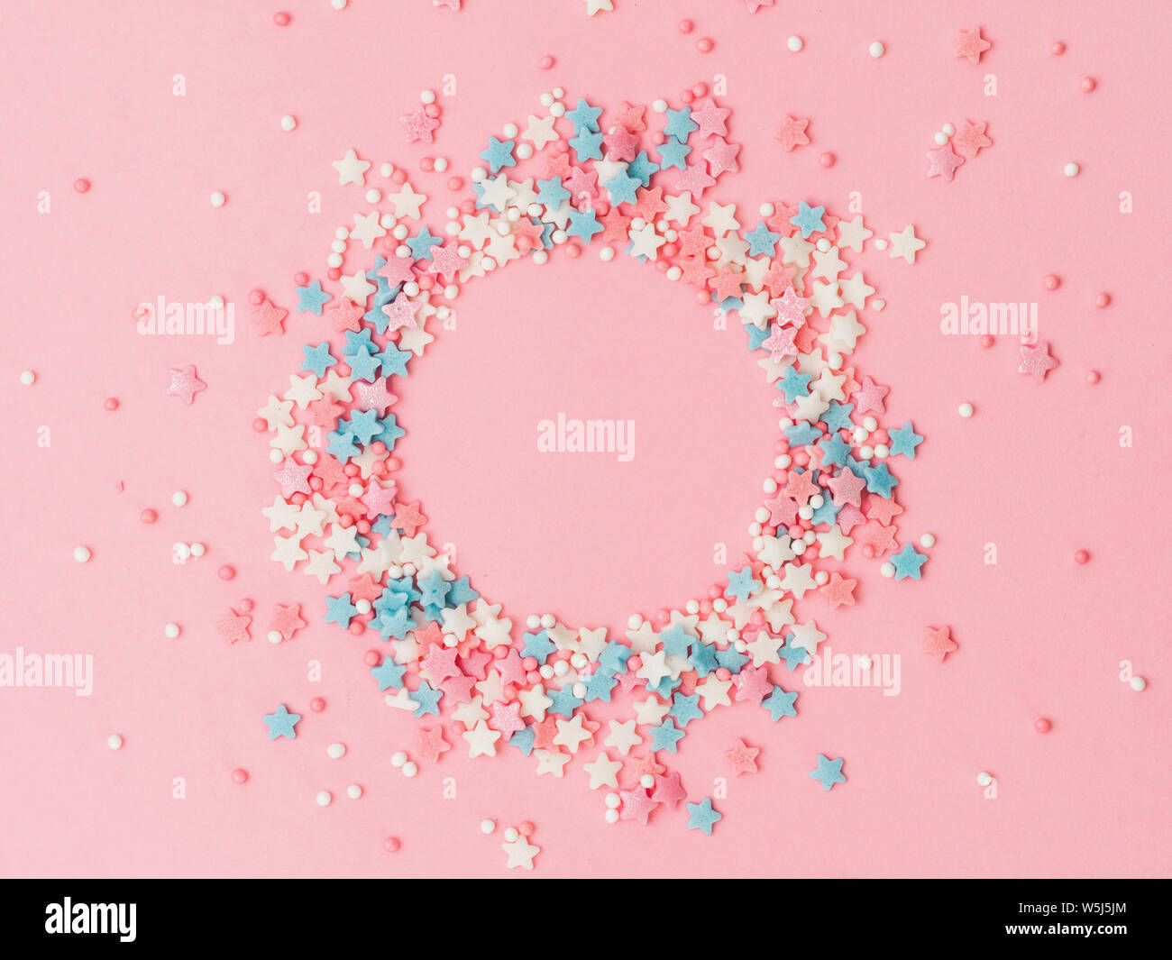 Festive border frame of colorful pastel sprinkles on pink background ...