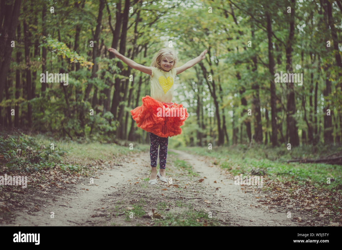 teenage girl in rural path among autumnal trees in forest Stock Photo ...