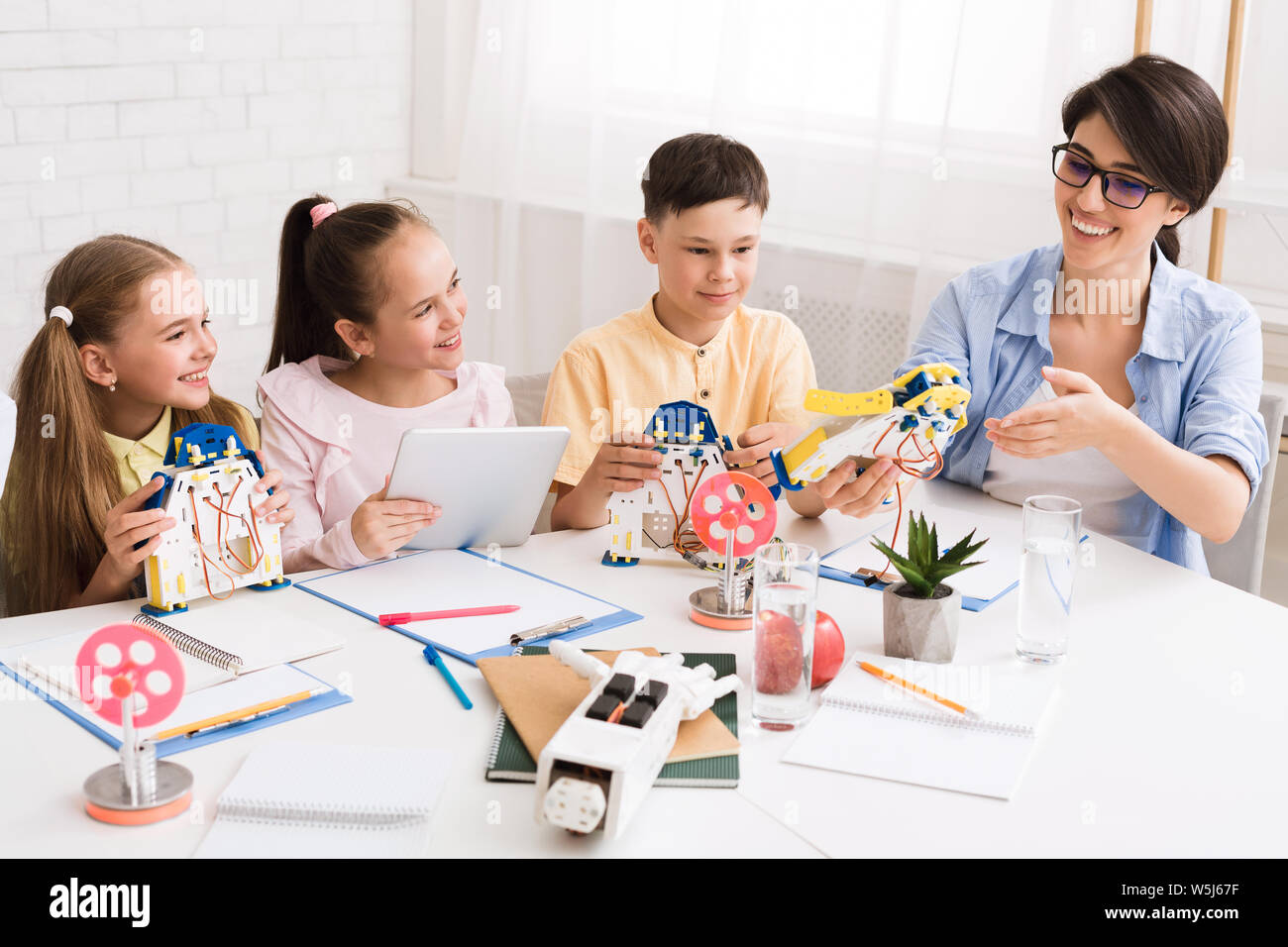 Stem education. Children creating robots with teacher Stock Photo - Alamy