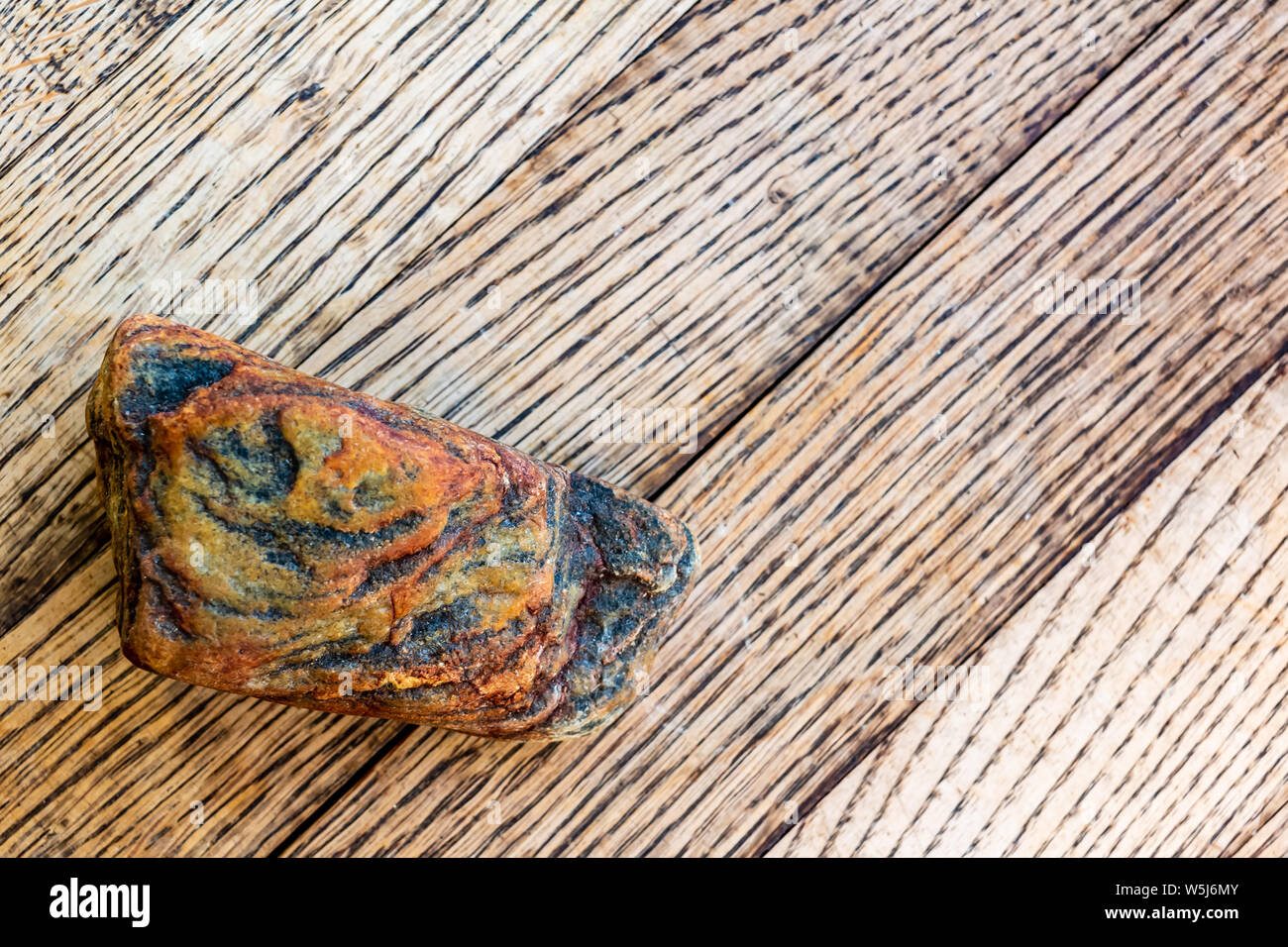 Colorful rainbow stone on rustic wood background Stock Photo - Alamy