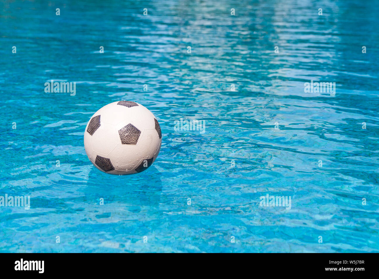 Soccer ball floating in the swimming pool Stock Photo - Alamy