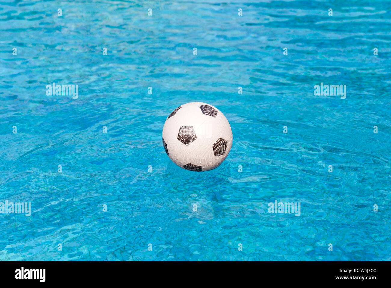 Soccer ball floating in the swimming pool Stock Photo - Alamy