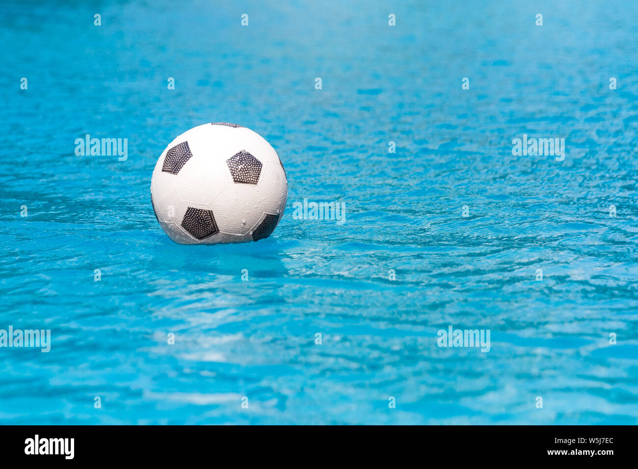 Soccer ball floating in the swimming pool Stock Photo - Alamy