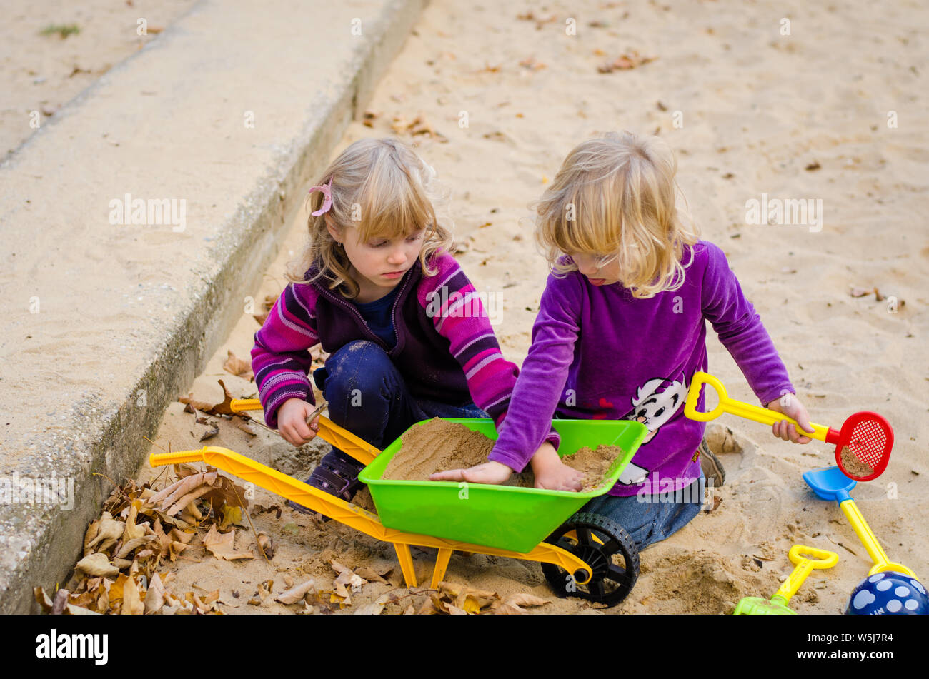two girls playing in the sandbox Stock Photo - Alamy