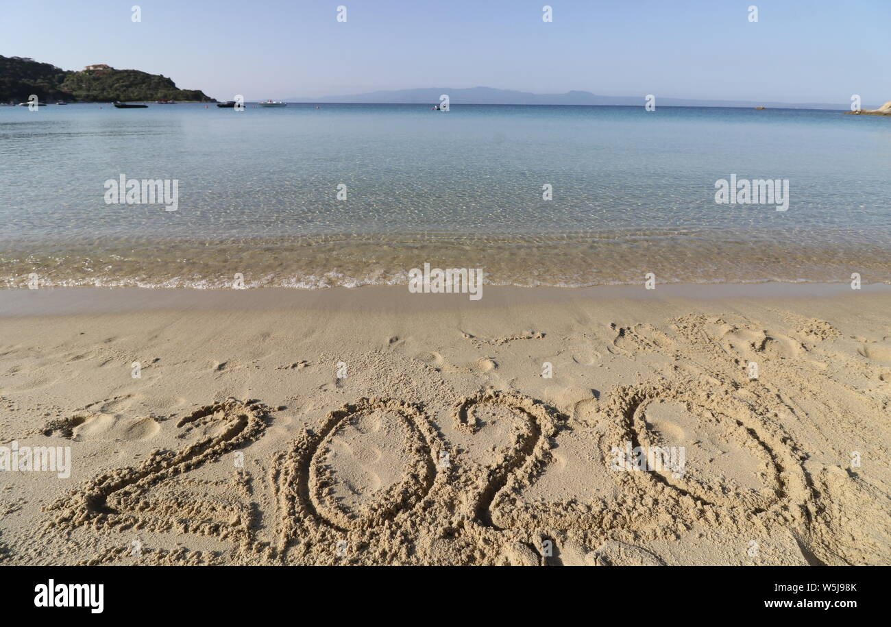 Happy New Year 2020, lettering on the beach with wave and clear blue ...