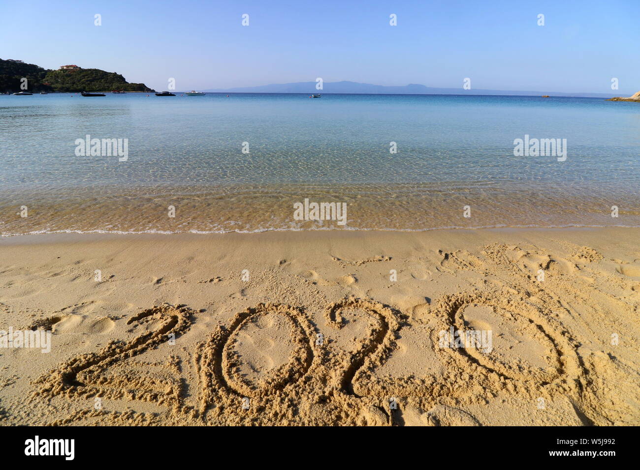 Happy New Year 2020, lettering on the beach with wave and clear blue ...