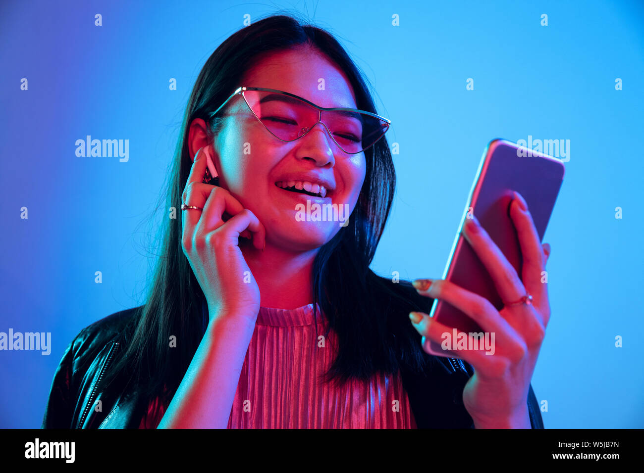 Beautiful female half-length portrait isolated on blue studio ...