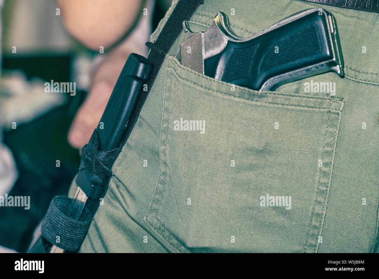 Gun in the back pocket Stock Photo - Alamy