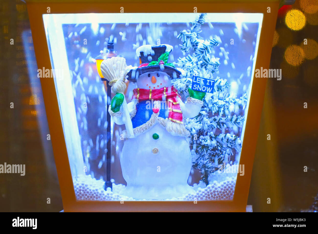 Toy snowman under the snow next to Christmas tree Stock Photo - Alamy
