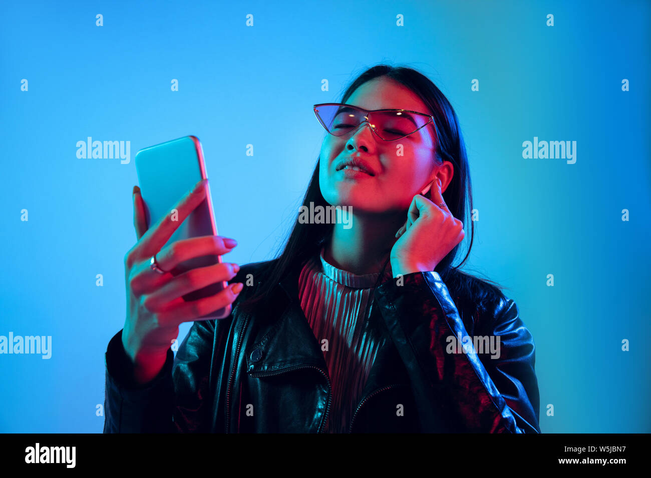 Beautiful female half-length portrait isolated on blue studio ...