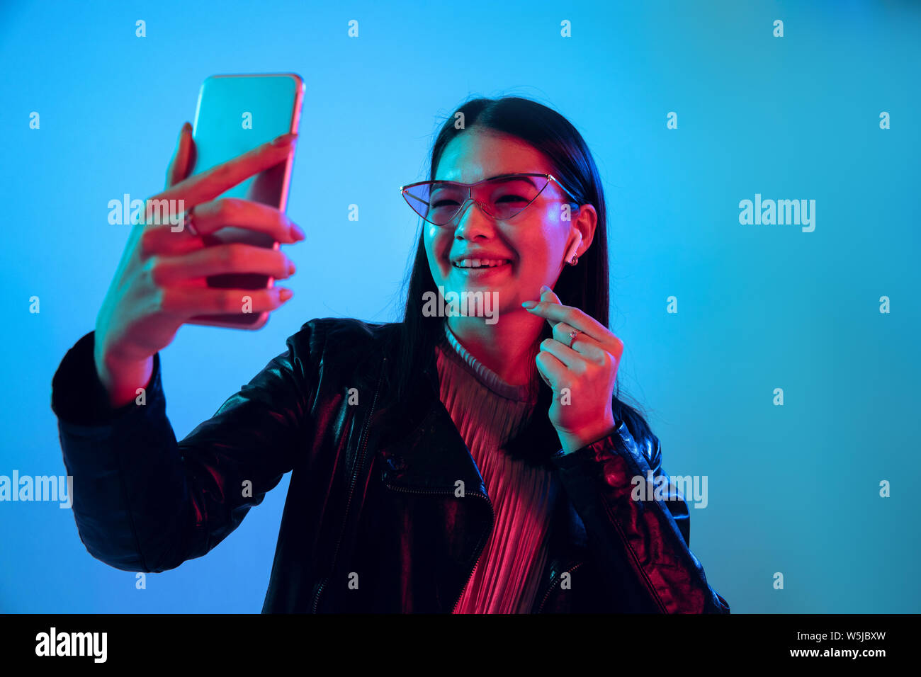Beautiful female half-length portrait isolated on blue studio ...