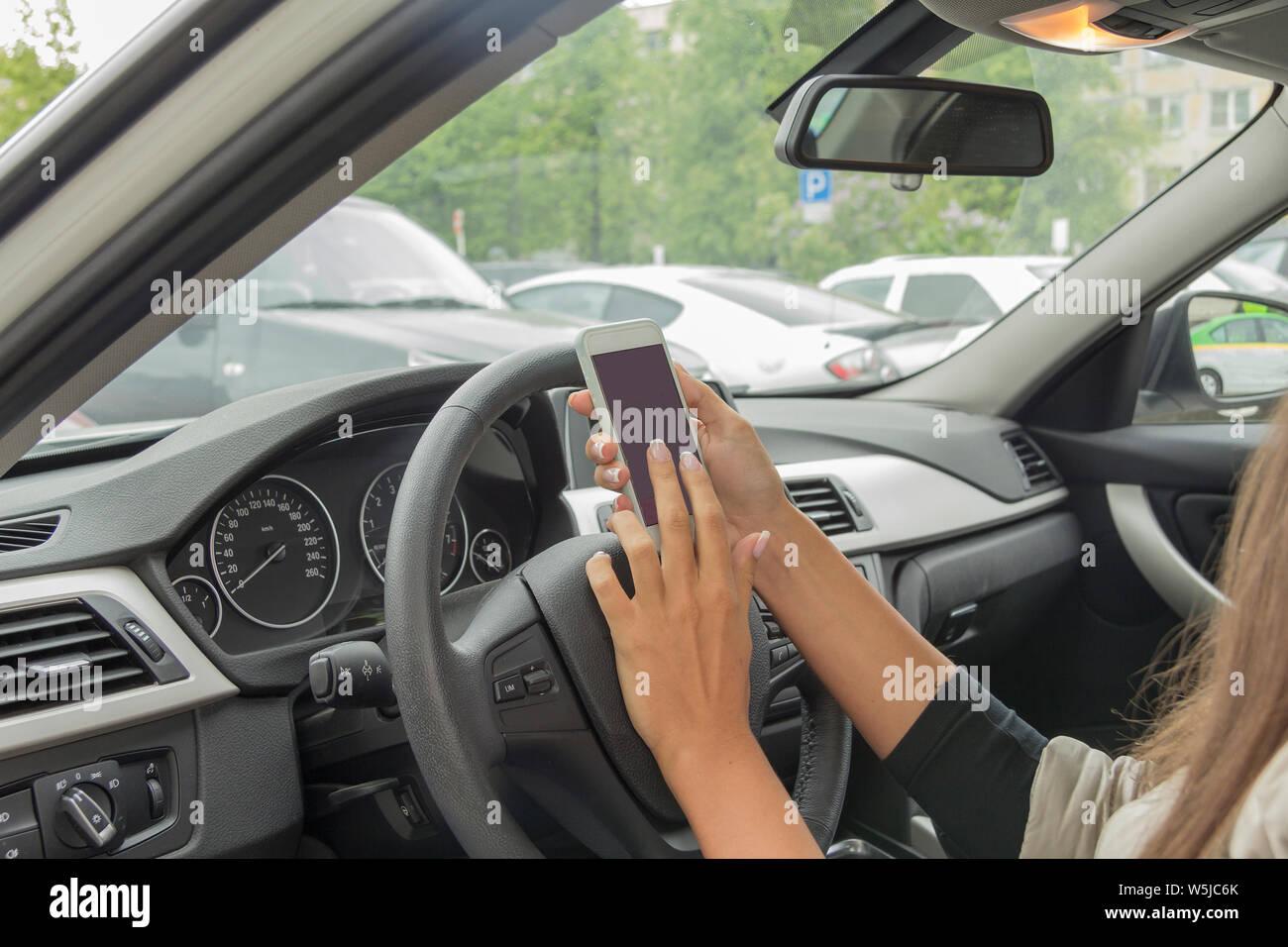 girl with a mobile phone behind the wheel in the saloon car Stock Photo ...