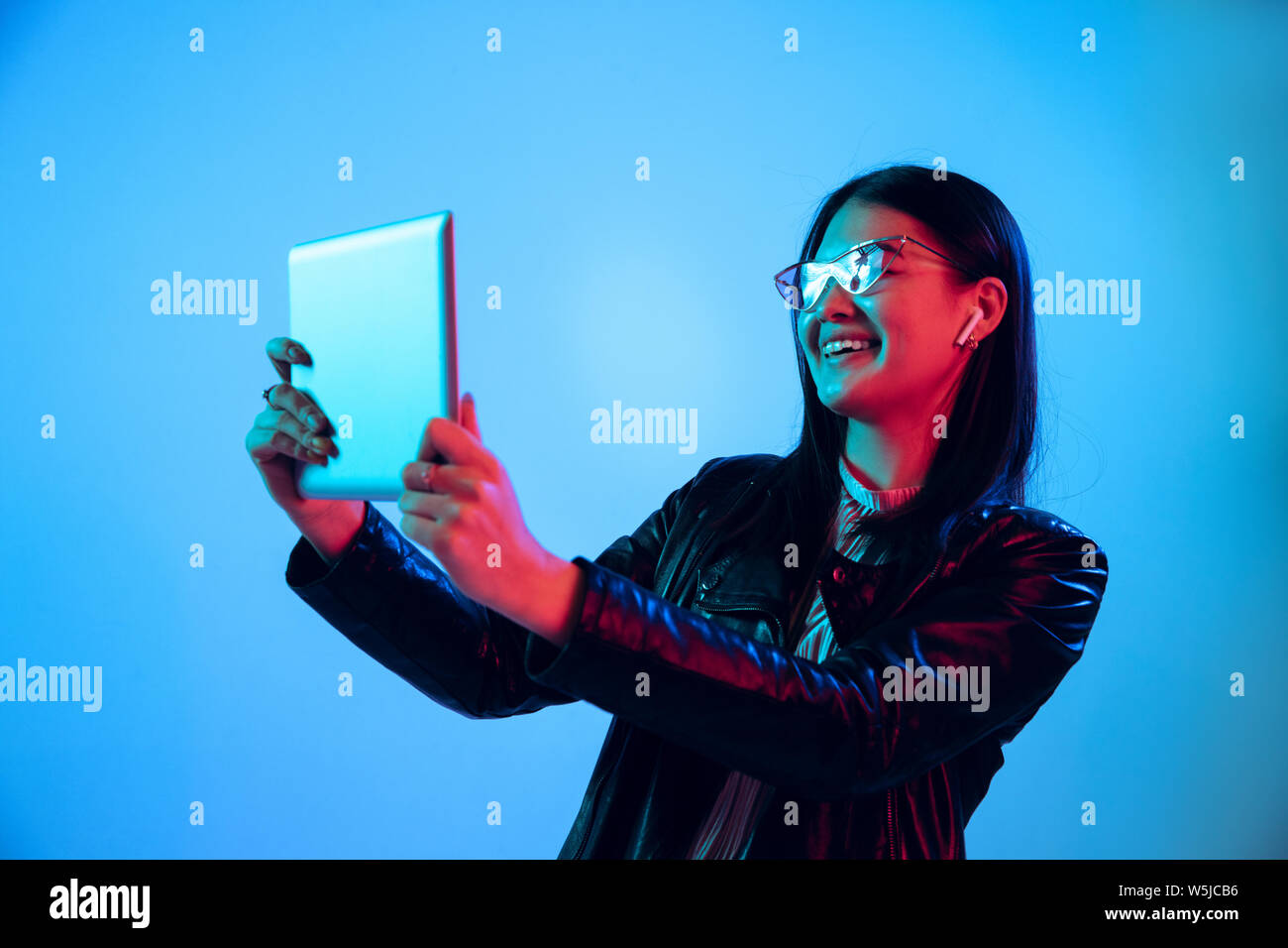 Beautiful female half-length portrait isolated on blue studio ...