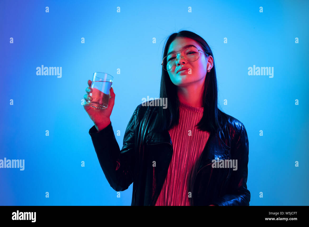 Beautiful female half-length portrait isolated on blue studio ...