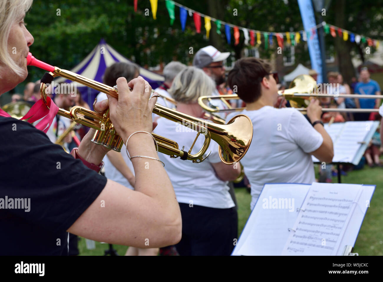 Woman playing trumpet in brass band outdoors at festival in Bristol ...
