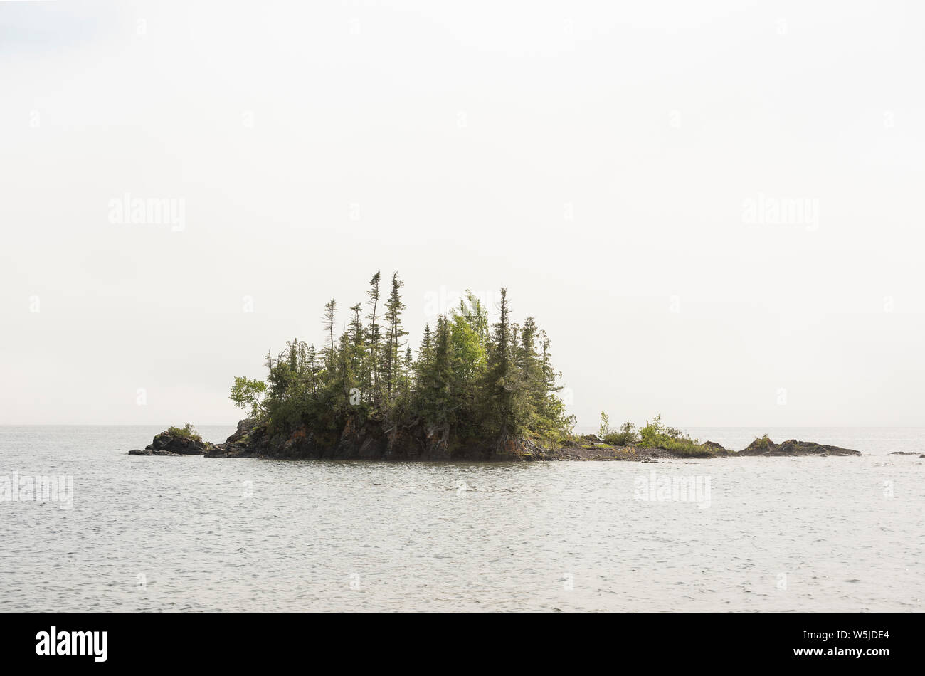 Small island with trees offshore on Lake Superior, just off the trans ...