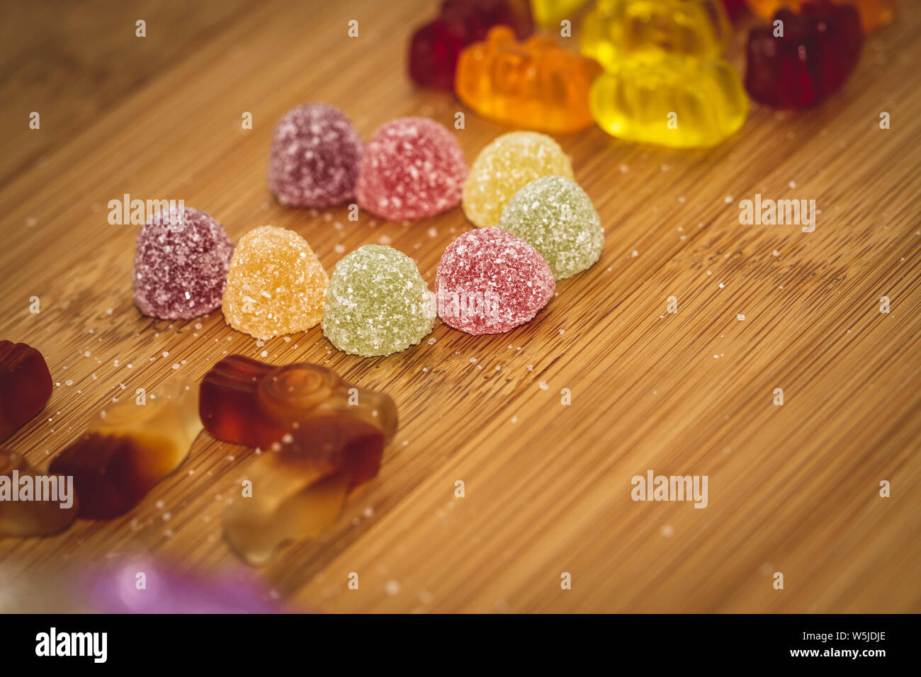 A portrait of some sugar coated sweets displayed on a wooden table ...