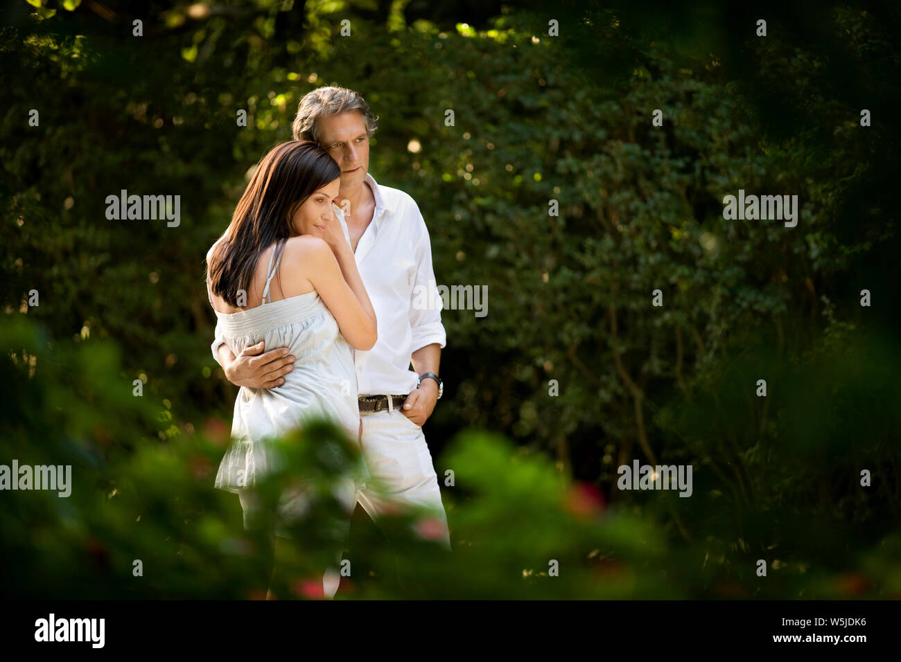 Husband and wife stand in embrace outdoors Stock Photo - Alamy
