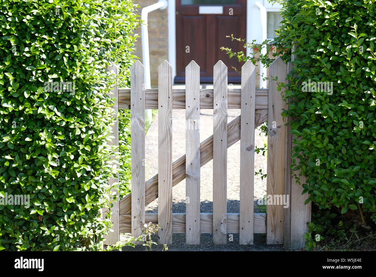 Wooden gate in the hedge leading to a private home Stock Photo - Alamy