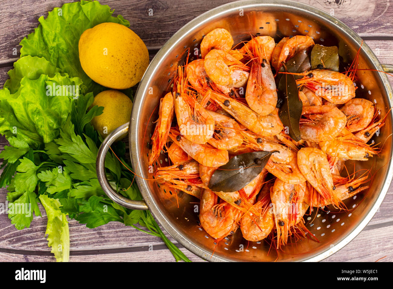 Cooked Atlantic prawns flow around in a stainless steel colander Stock ...