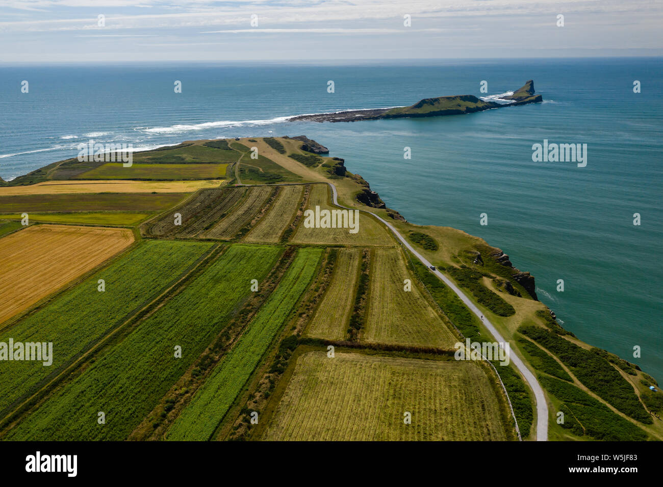 Aerial view of green fields and the ocean in Rhossili on the Gower ...
