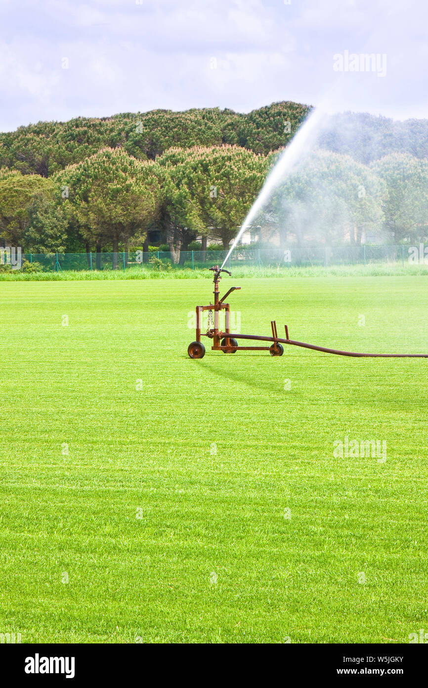 Metal irrigator in a green mowed lawn Stock Photo - Alamy