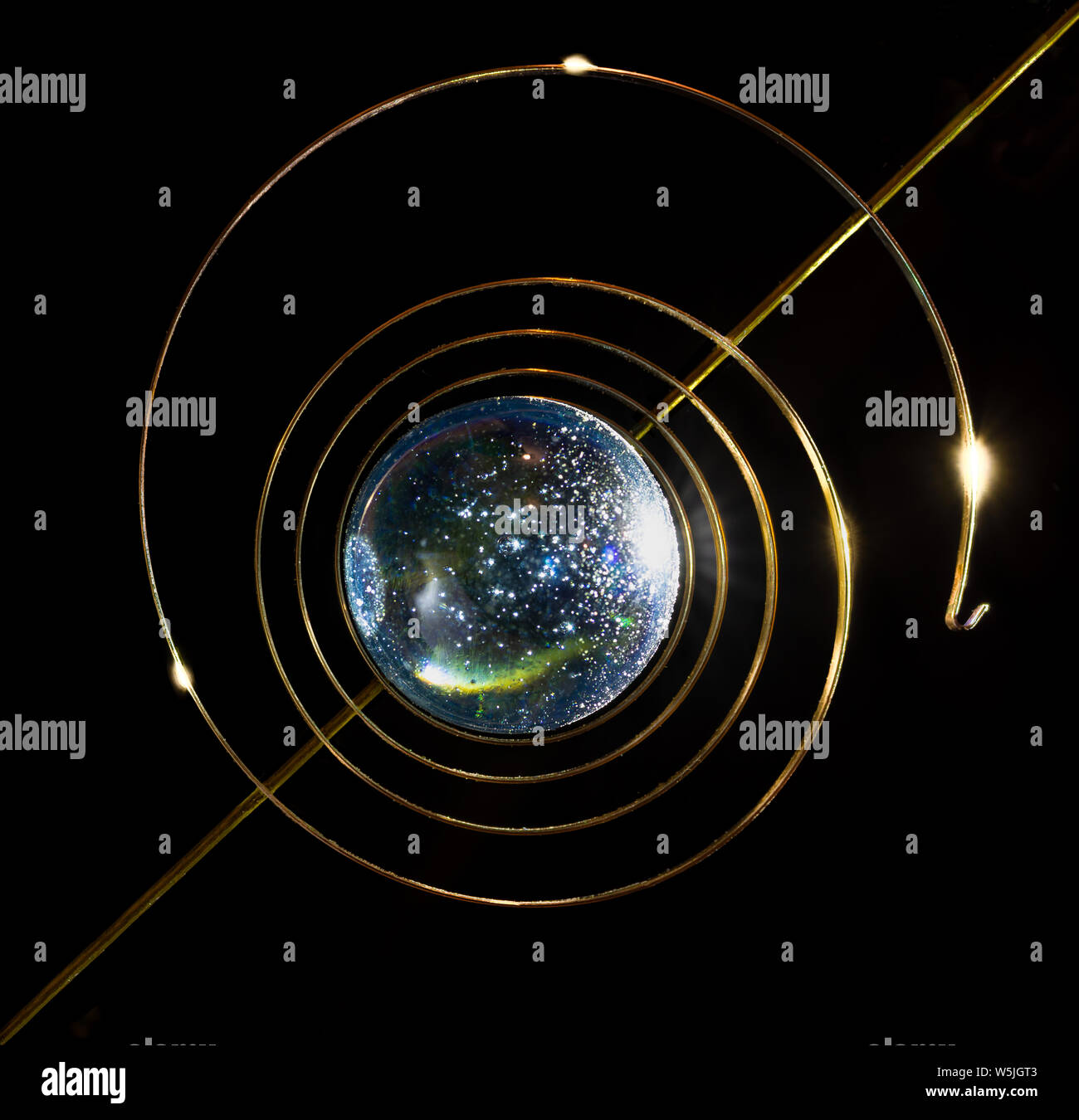 Glass ball on metal spring Stock Photo - Alamy