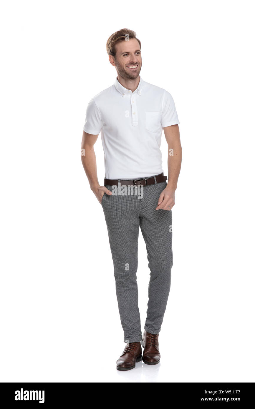 relaxed smiling smart casual man looks to side while standing on white ...