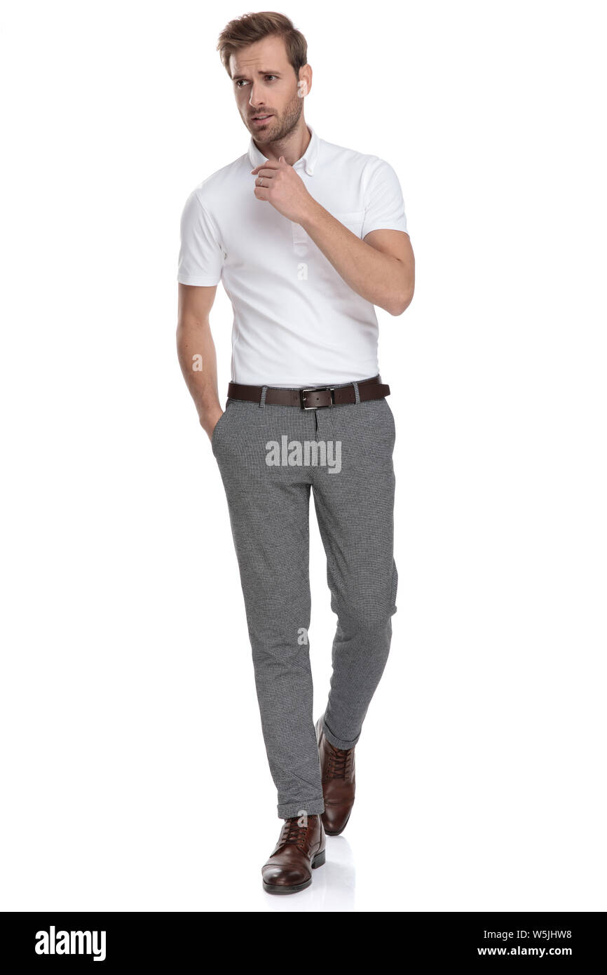 smart casual man with hand in pocket is walking and thinking while ...