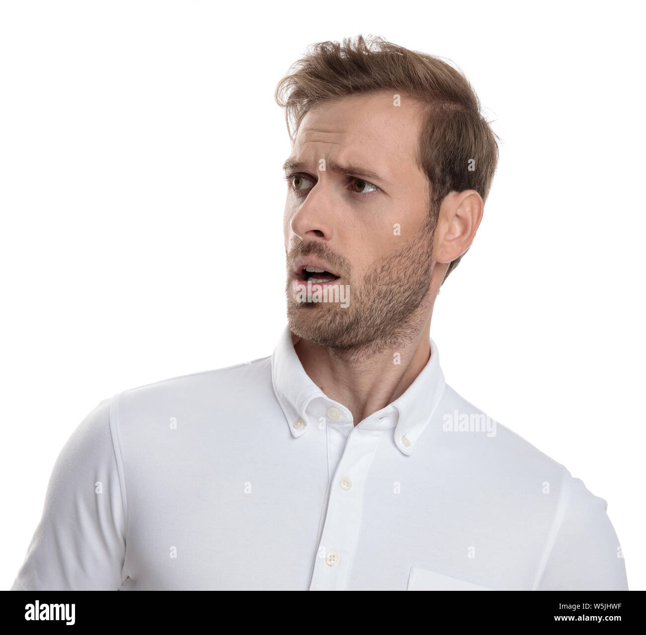 shocked young man looks to side on white background Stock Photo - Alamy