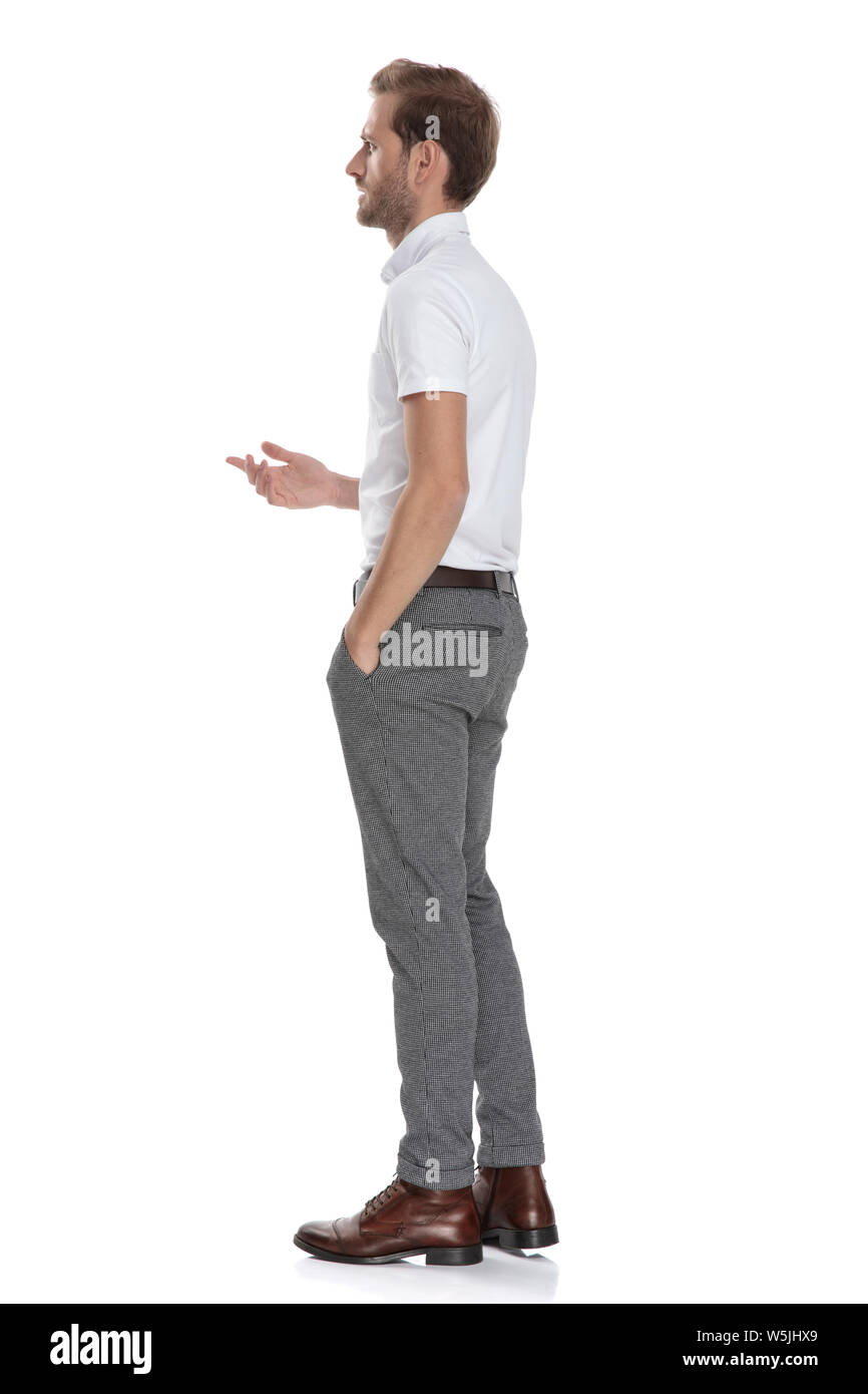 side view of a man gesturing as if he is talking with someone on white ...