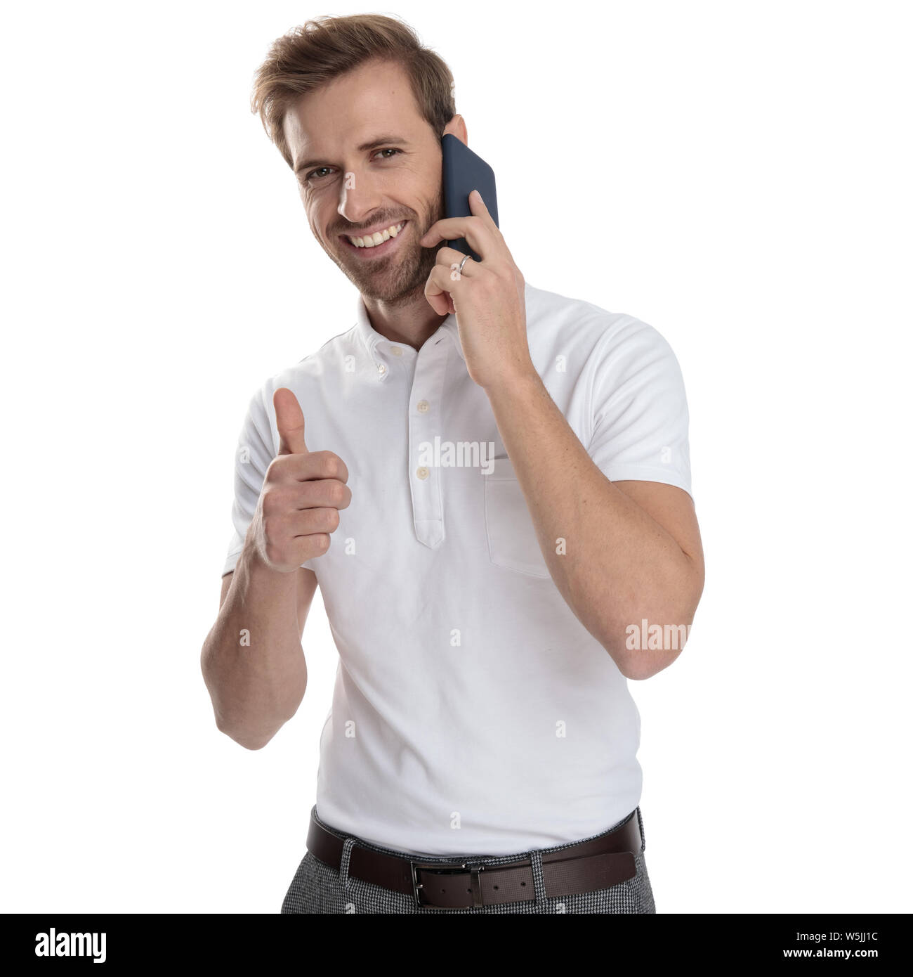 happy casual man makes the ok sign while talking on the phone on white ...