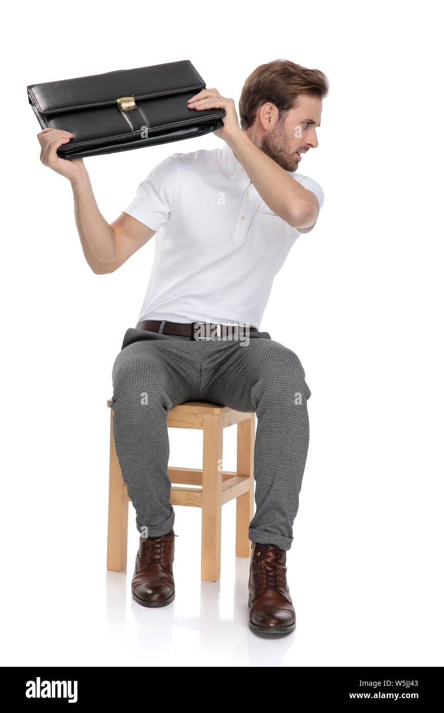 aggressive man threatening to hit someone with his briefcase while ...