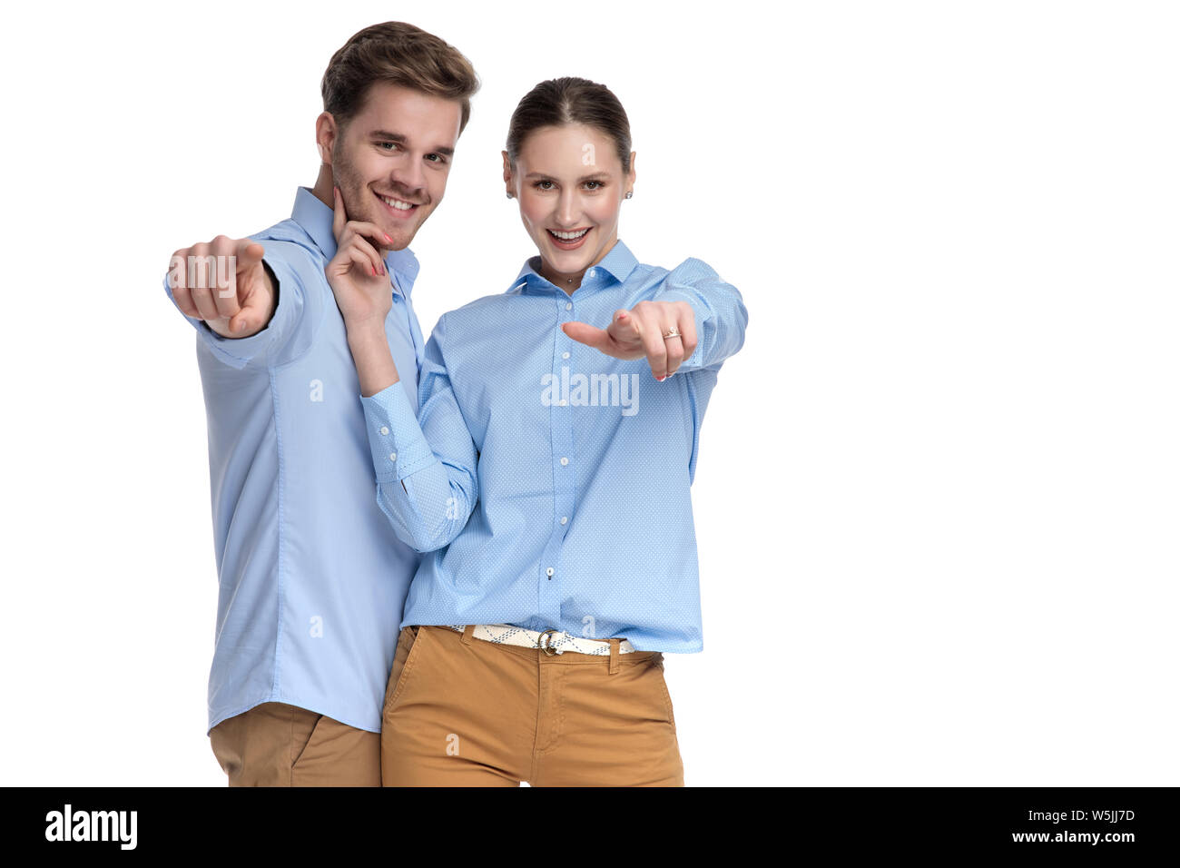 happy young casual couple pointing fingers together on white background ...