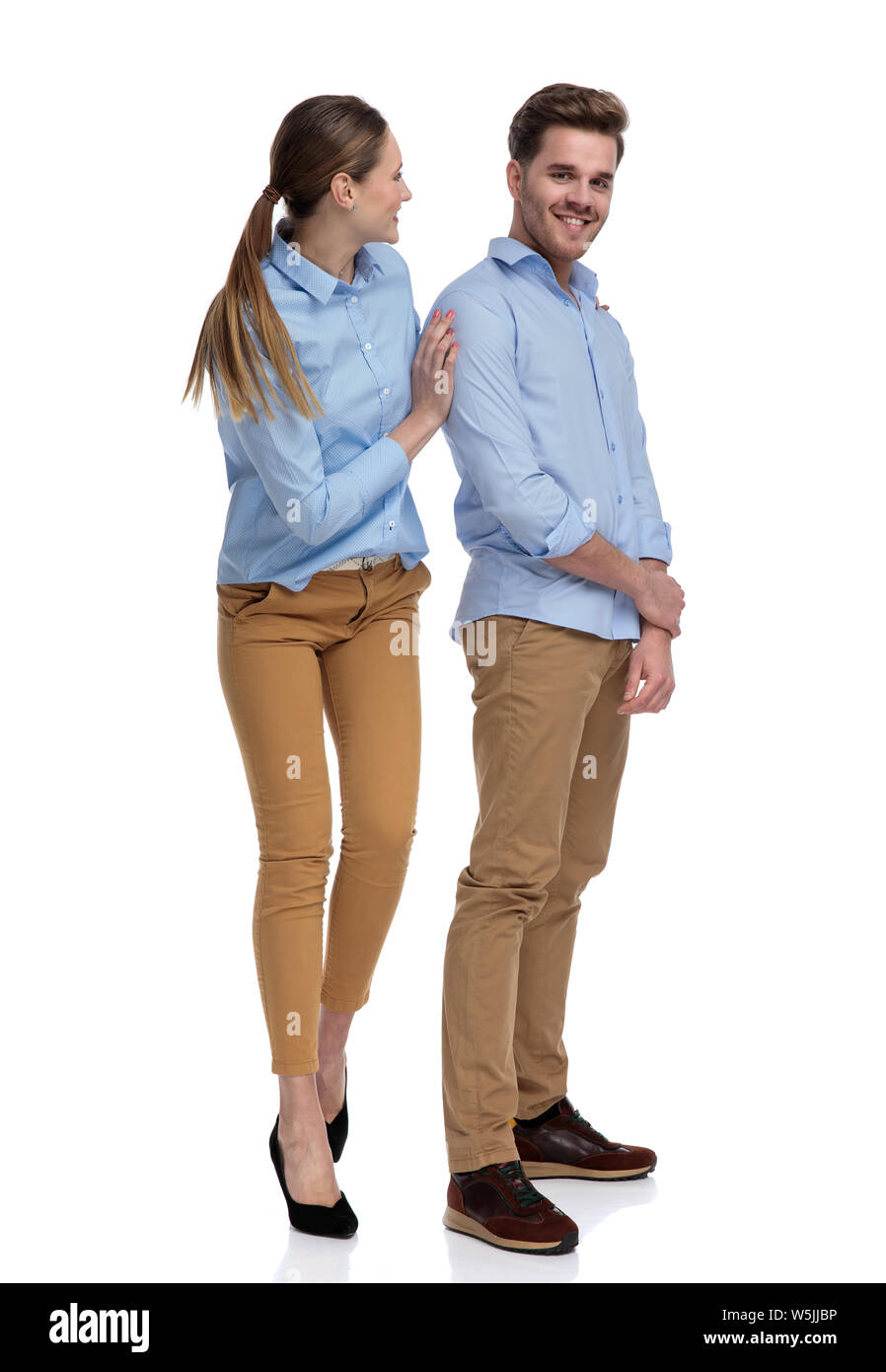 laughing casual woman standing behind man holding his shoulders on ...