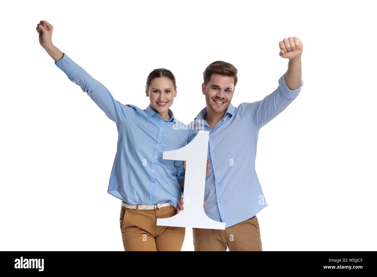 happy casual couple celebrating first place by holding a number one on ...