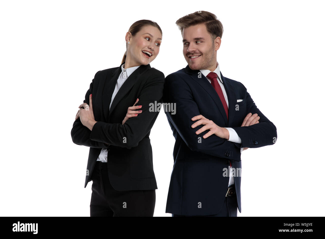 couple in business suits standing back to back with crossed arms on ...