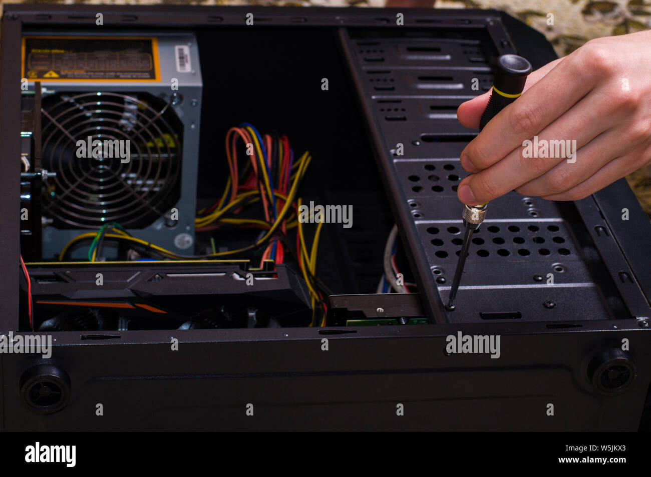 Computer repairing. Man repair black pc Stock Photo - Alamy