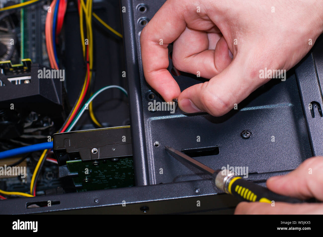 Computer repairing. Man repair black pc Stock Photo - Alamy