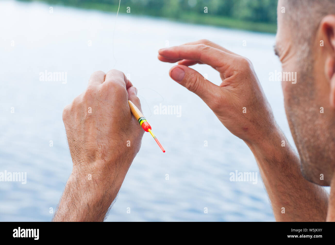 Man unraveling to the tangled and knotted Fishing line. Problem solving ...