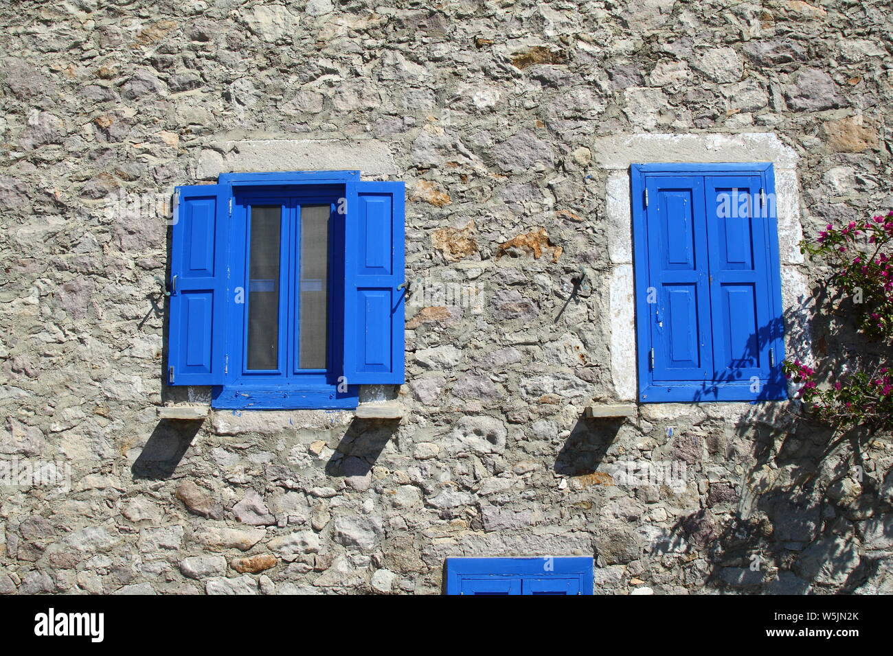 Open and closed light blue wooden window blinds on windows of newly ...