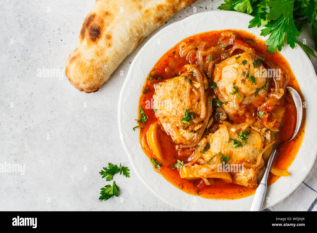 Georgian traditional chicken chakhokhbili in a white plate, white ...