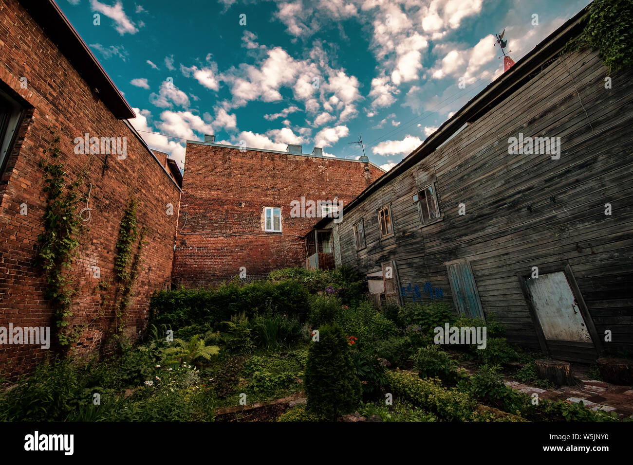 slums of the old town with a wooden house and a large old brick wall ...