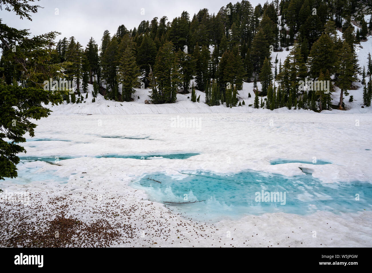 Frozen Emerald Lake in Lassen National Park with blue ice and snow, in ...