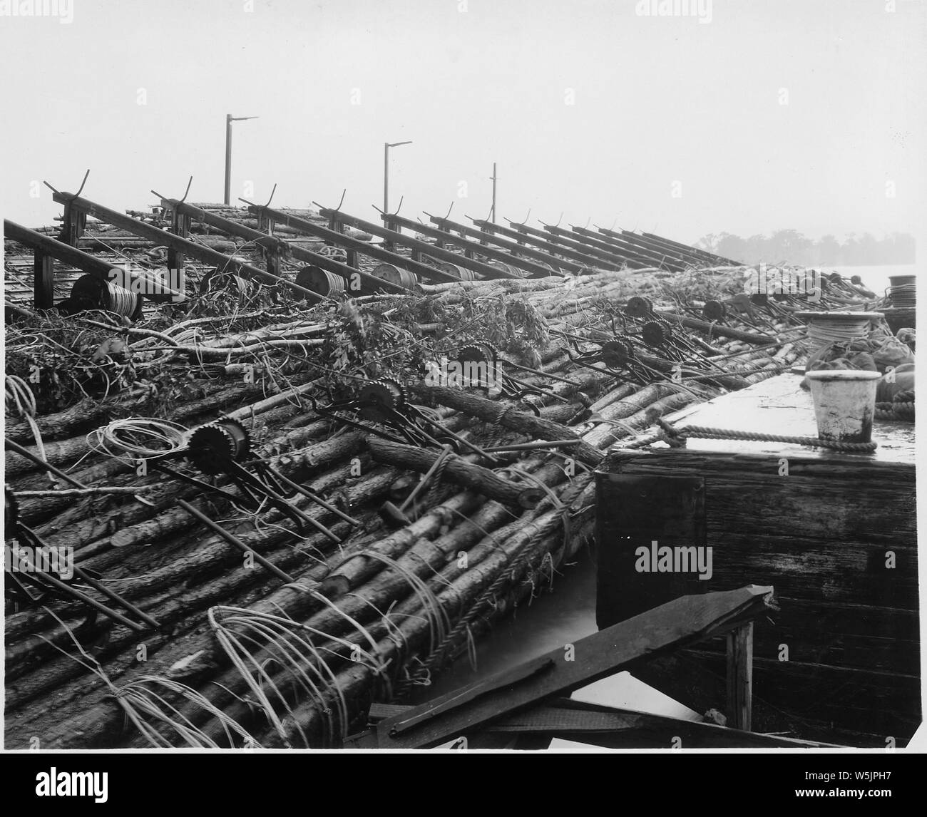 A barge sits along a log piling on the river Stock Photo - Alamy