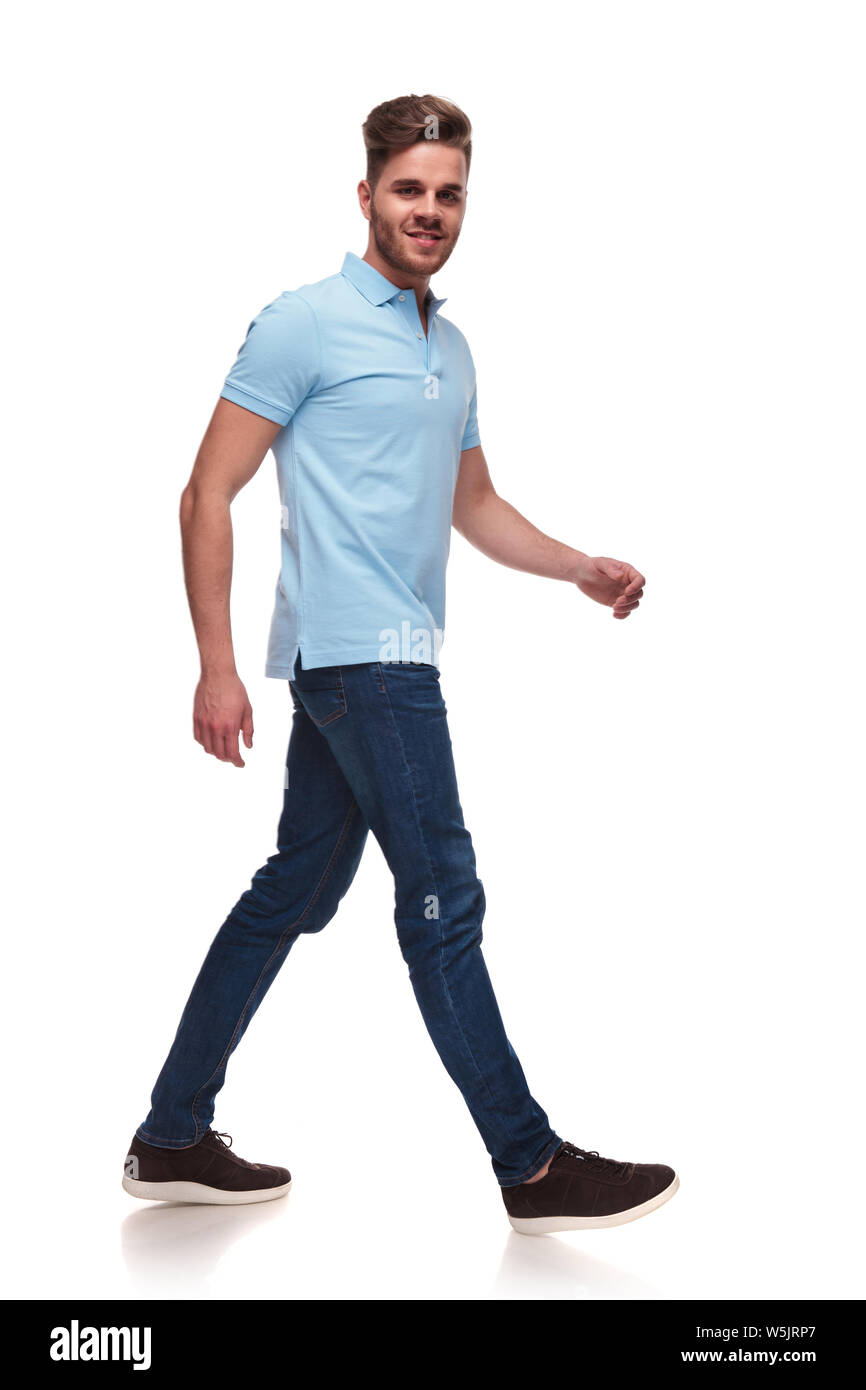 side view of joyful and handsome casual man wearing a blue polo shirt ...