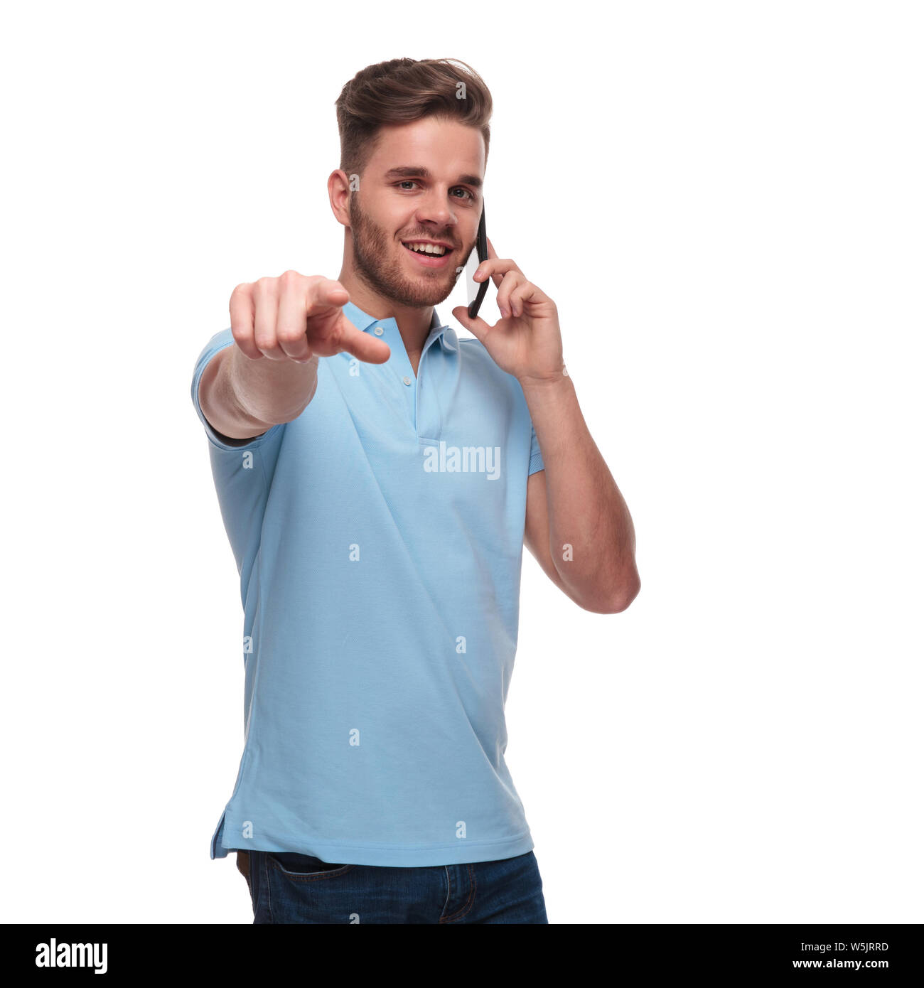 portrait of handsome casual man talking on the phone and pointing ...