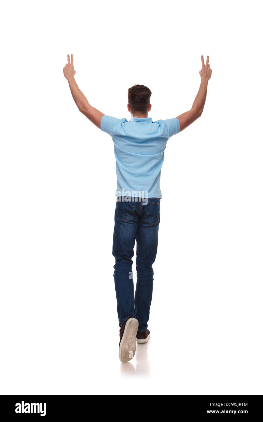back view of casual man celebrating and making peace sign while ...